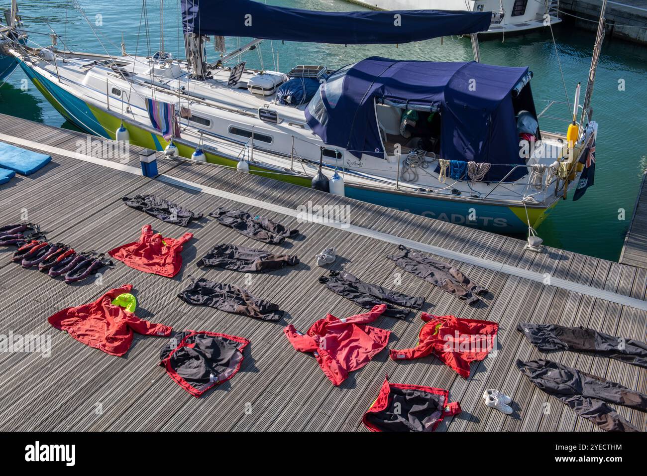 waterproof and weatherproof sailing clothing drying on a pontoon in a ...