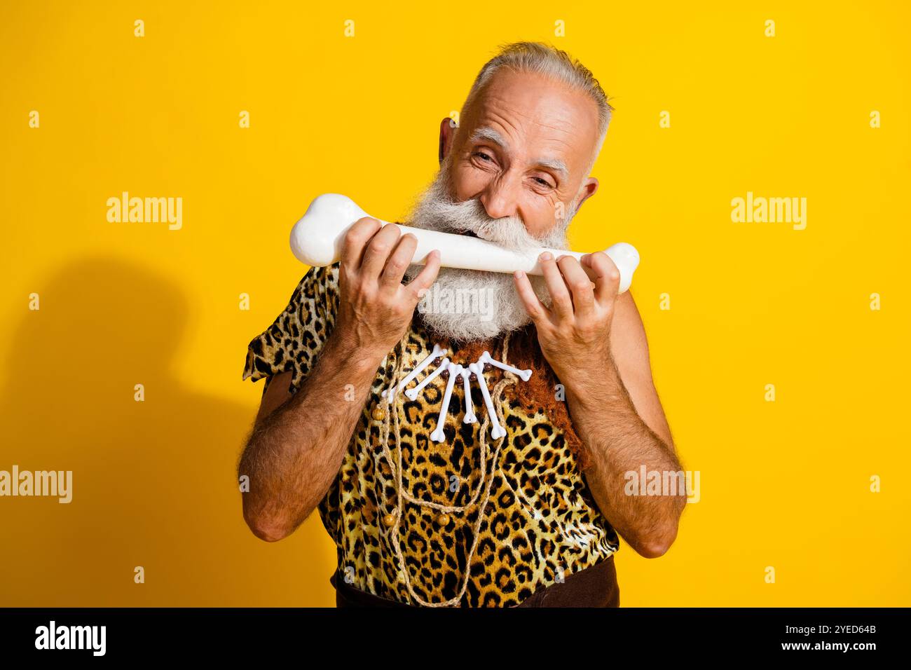 Photo of ancient aged caveman bit eat bone wear leopard skin clothes ...