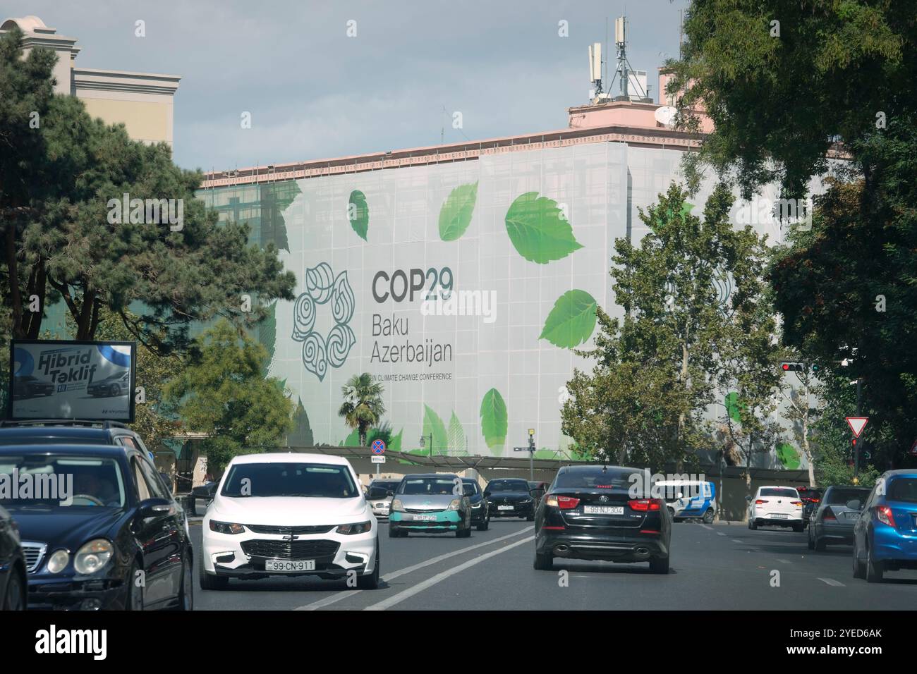 Vehicles drive near a logo for the COP29 United Nations Climate Change ...