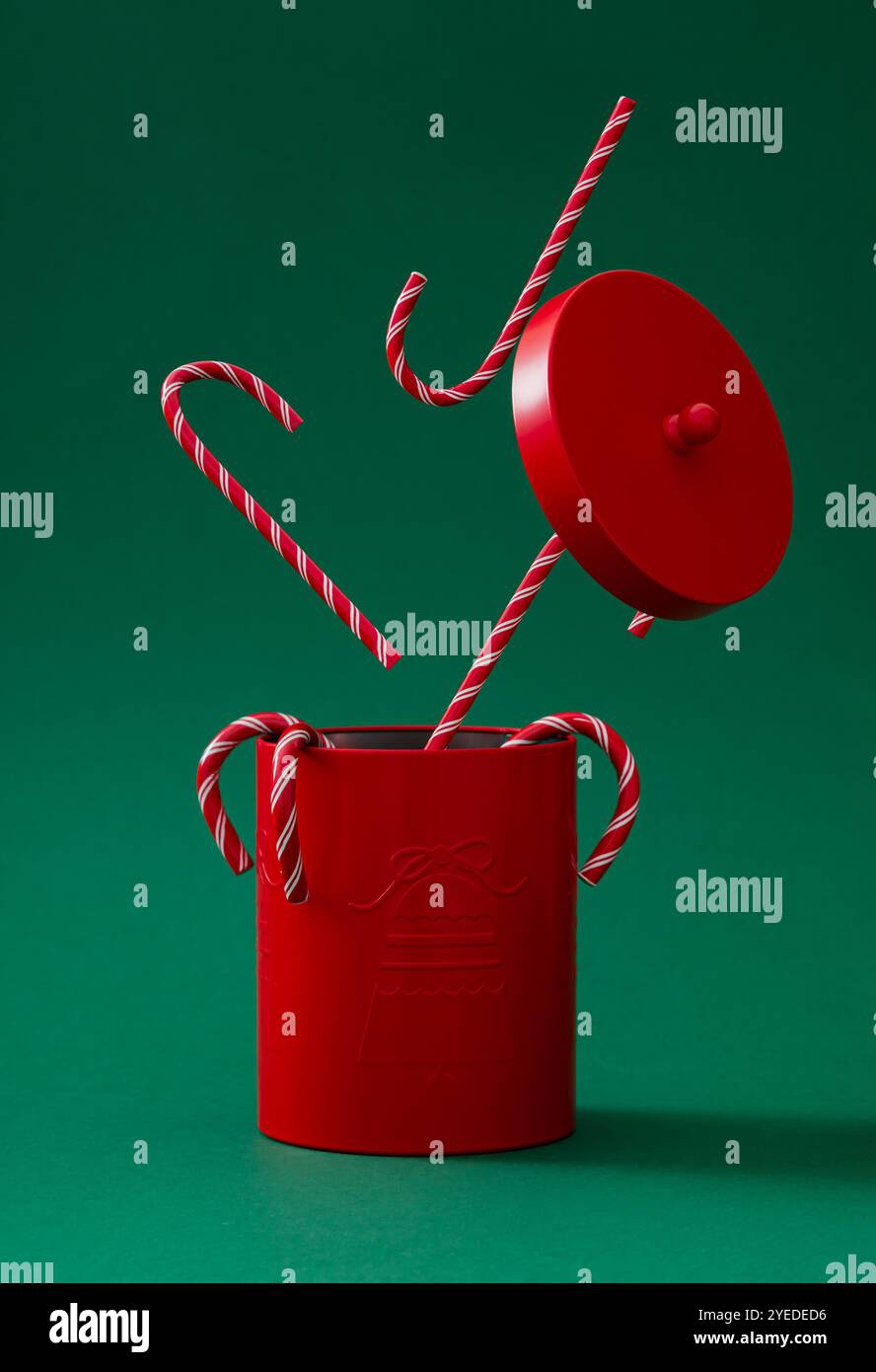 Christmas candy canes coming out of red Xmas tin decorated with classic ...