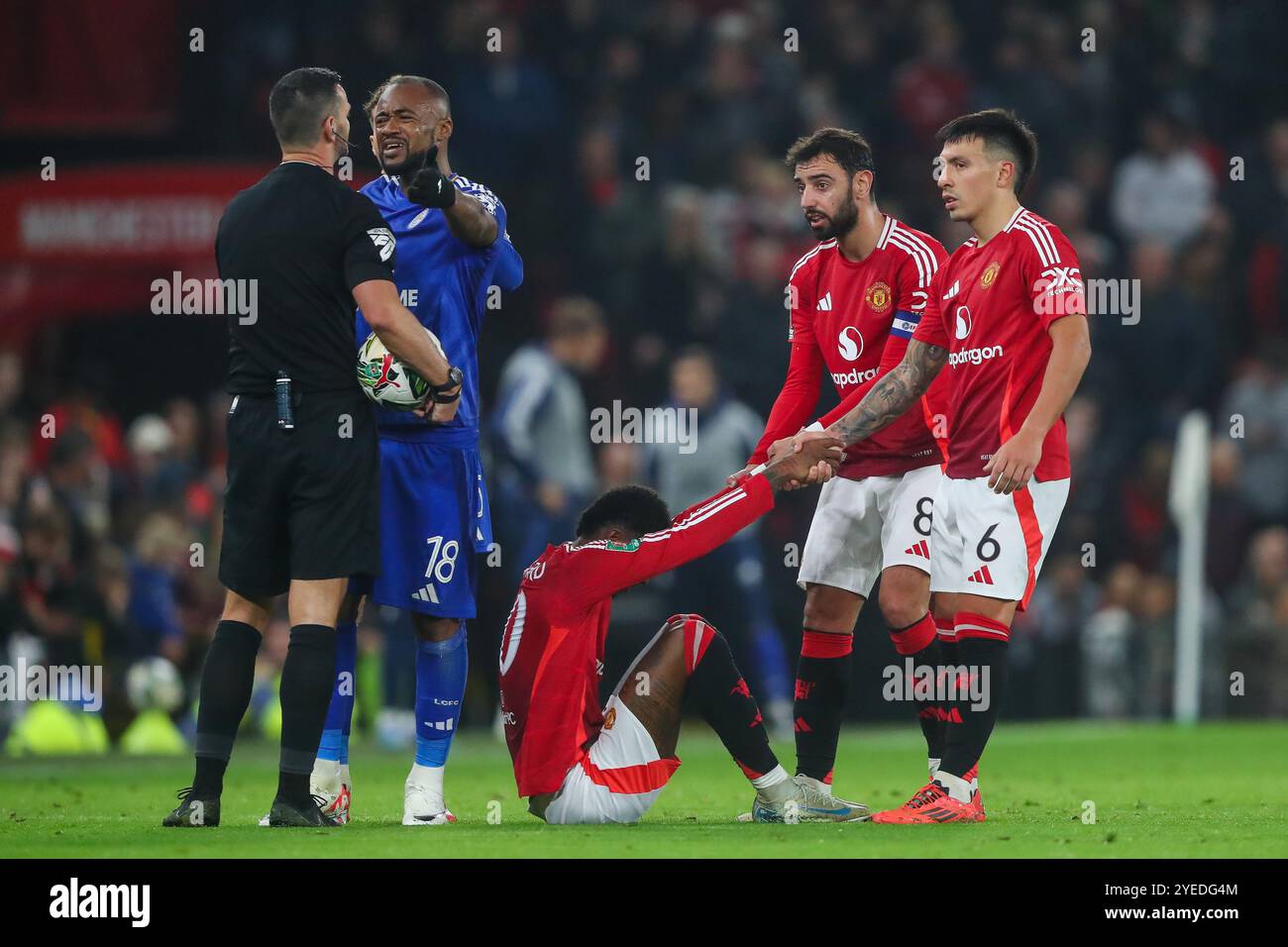 Marcus Rashford of Manchester United is helped to his feet by Lisandro ...
