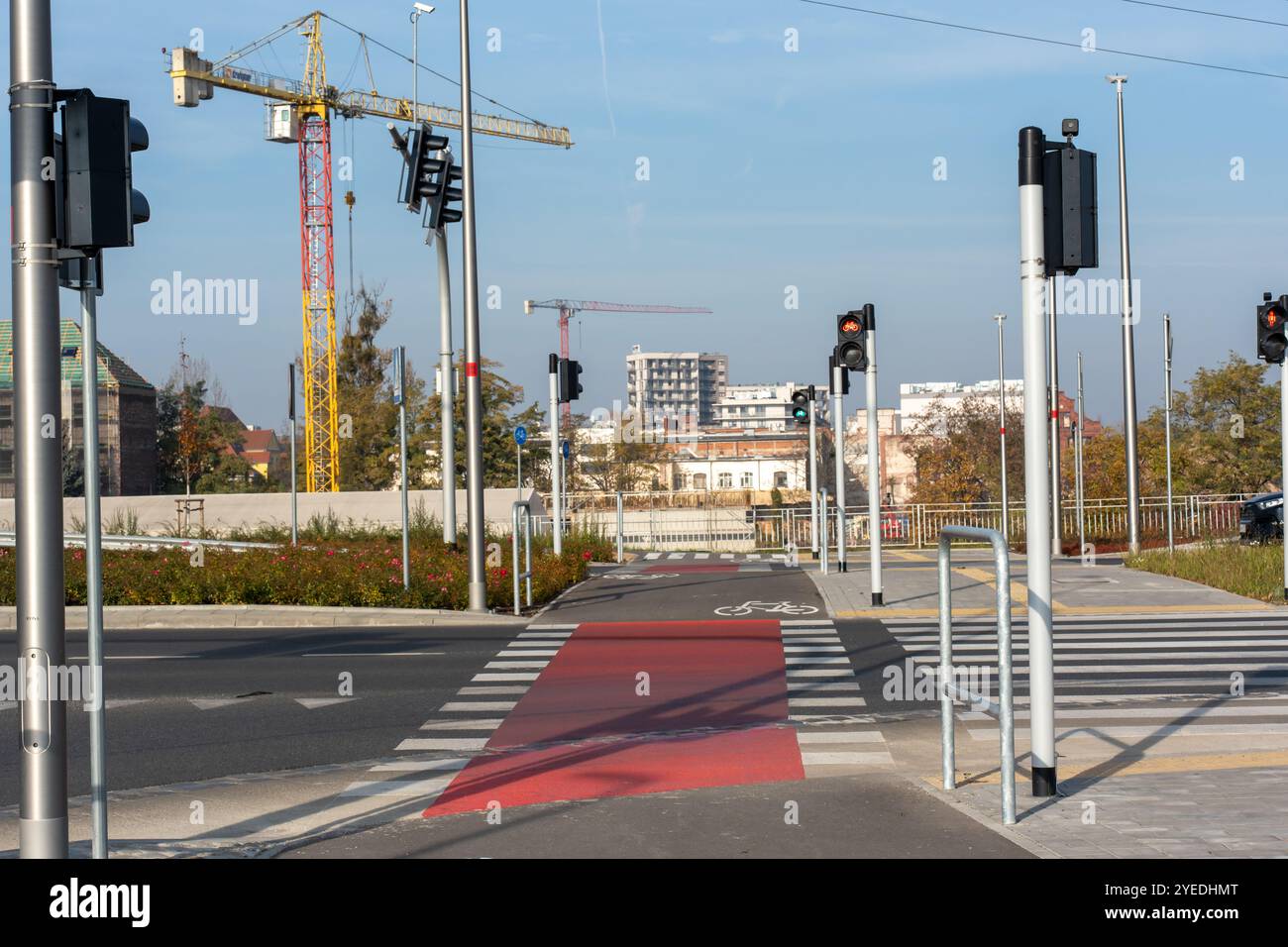 Modern urban intersection with bike lane, crosswalks and traffic lights ...