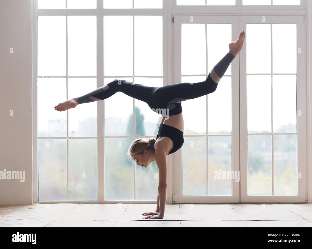 Young sporty woman balancing on hands with splitted legs Stock Photo ...