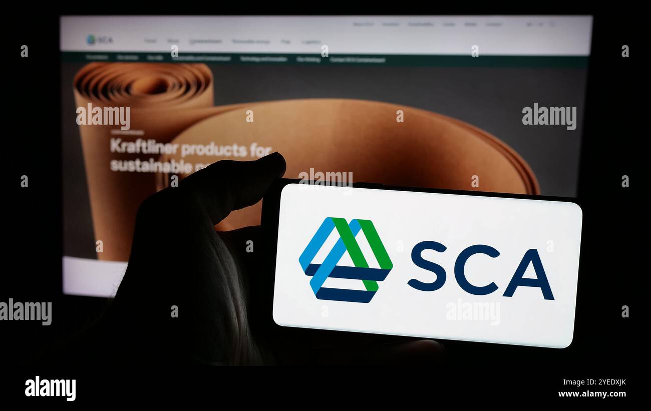 Person holding smartphone with logo of Swedish company Svenska ...