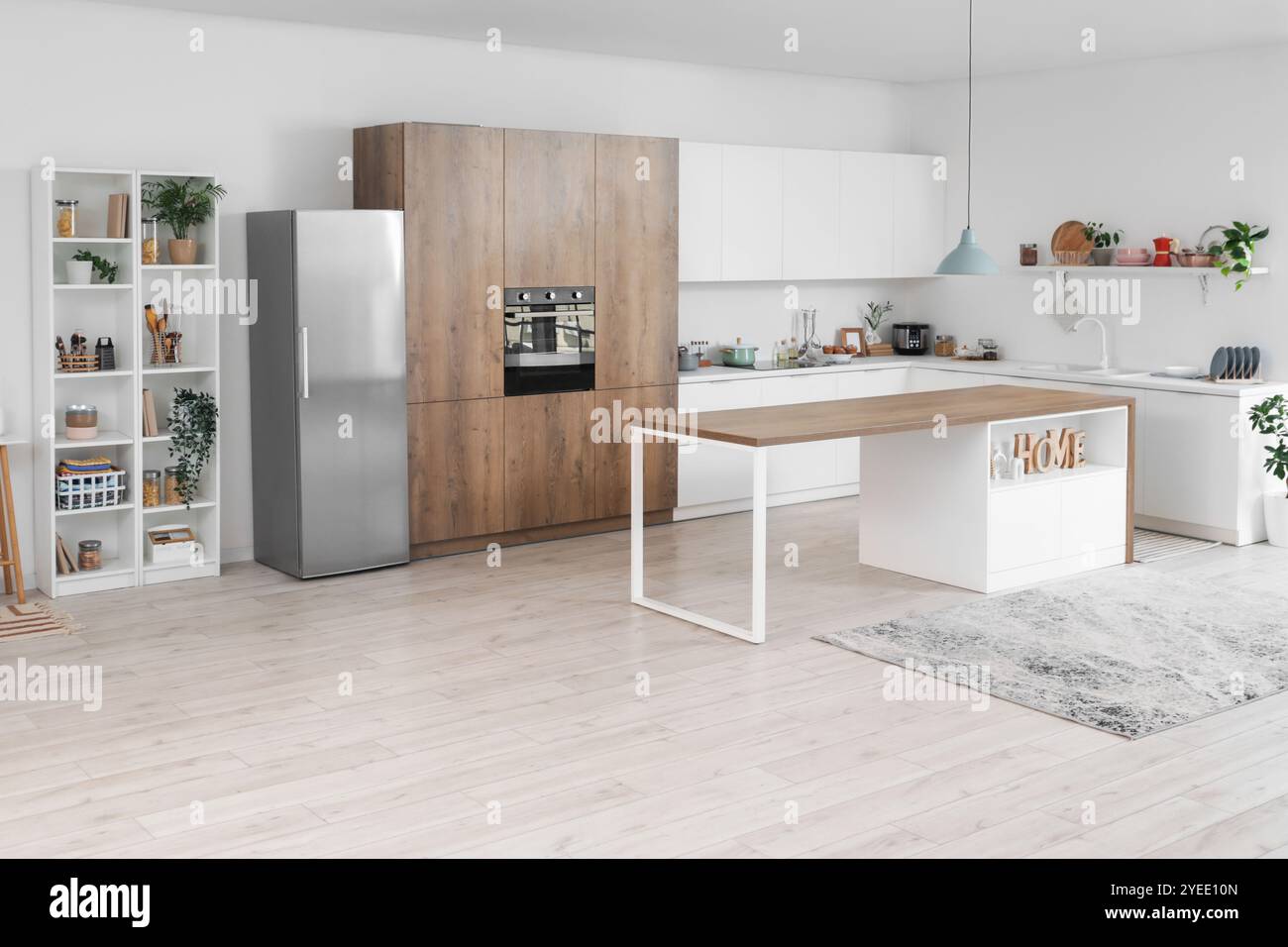 Interior of light kitchen with silver fridge, white counters and shelf ...