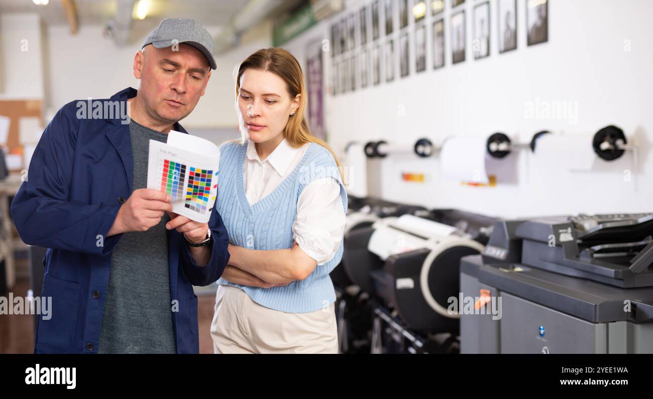 Service engineer and office worker checking color chart test page ...