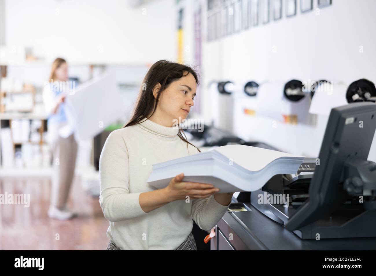 Woman loading ream of paper into printer Stock Photo - Alamy