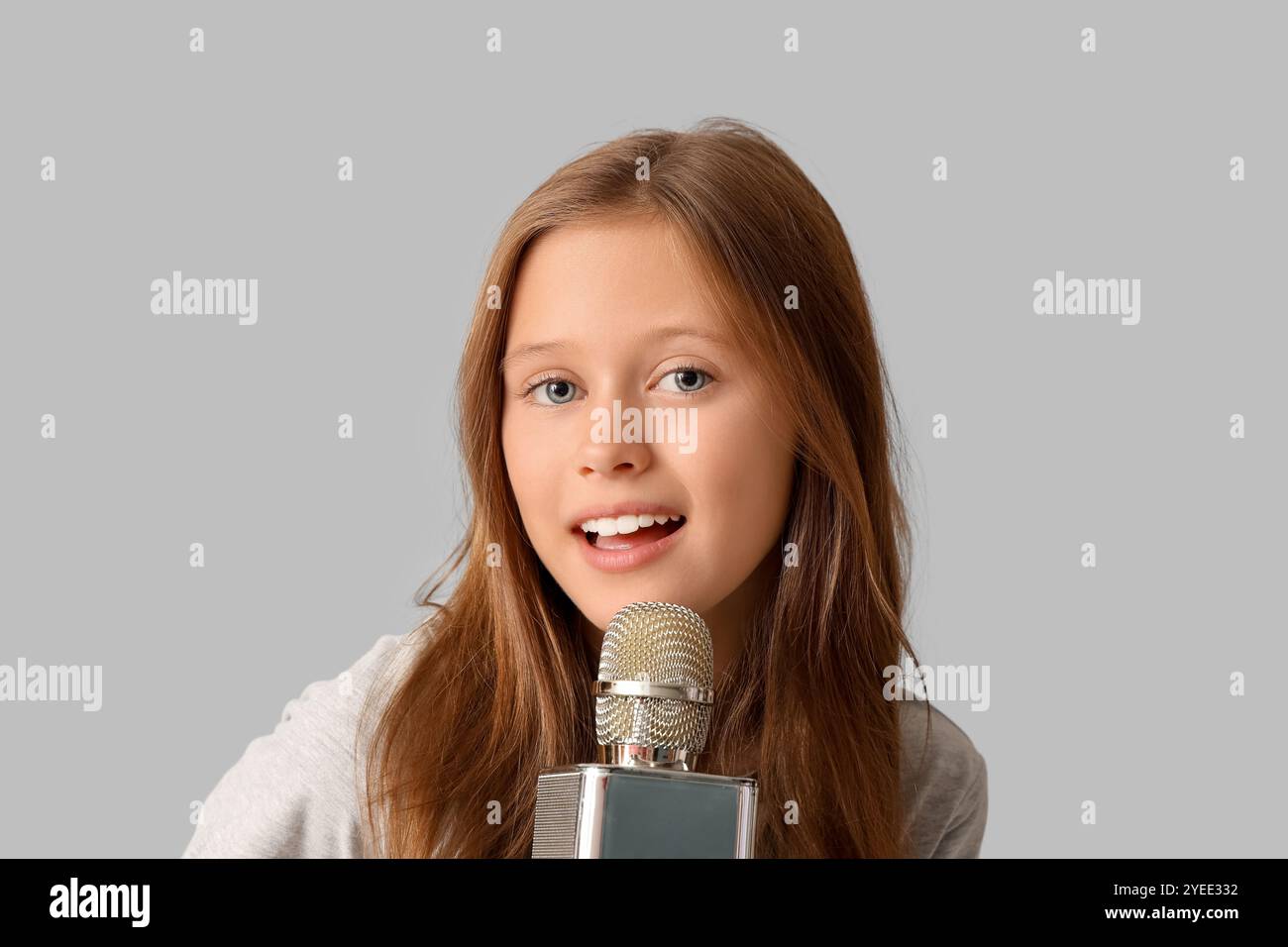 Cute girl with modern microphone on grey background Stock Photo - Alamy