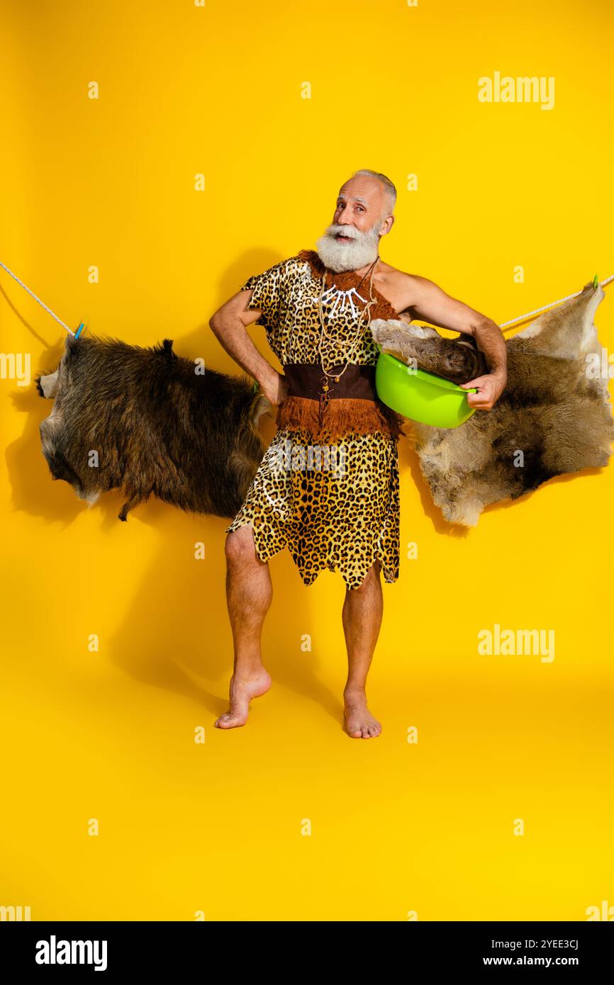 Photo of strong caveman standing posing with basket animal fur isolated ...