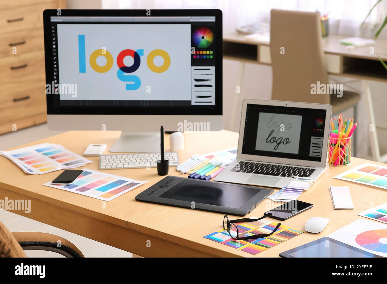 Workspace of graphic designer with modern computer, tablet, laptop and ...