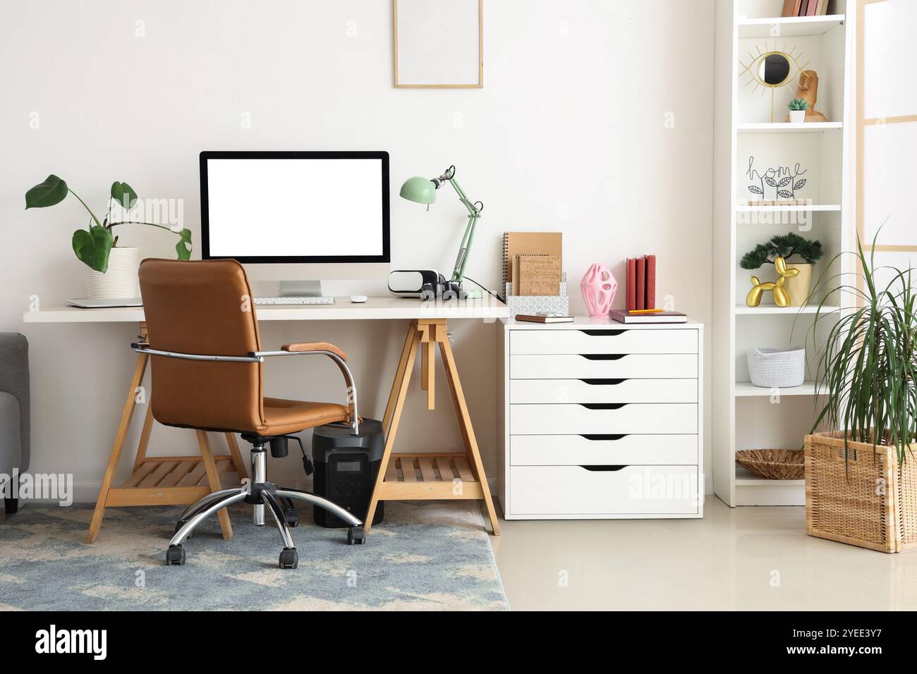 Interior of living room with workplace and shelf unit Stock Photo - Alamy
