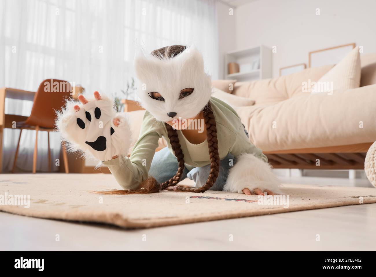 Quadrober girl in cat mask on carpet at home Stock Photo - Alamy