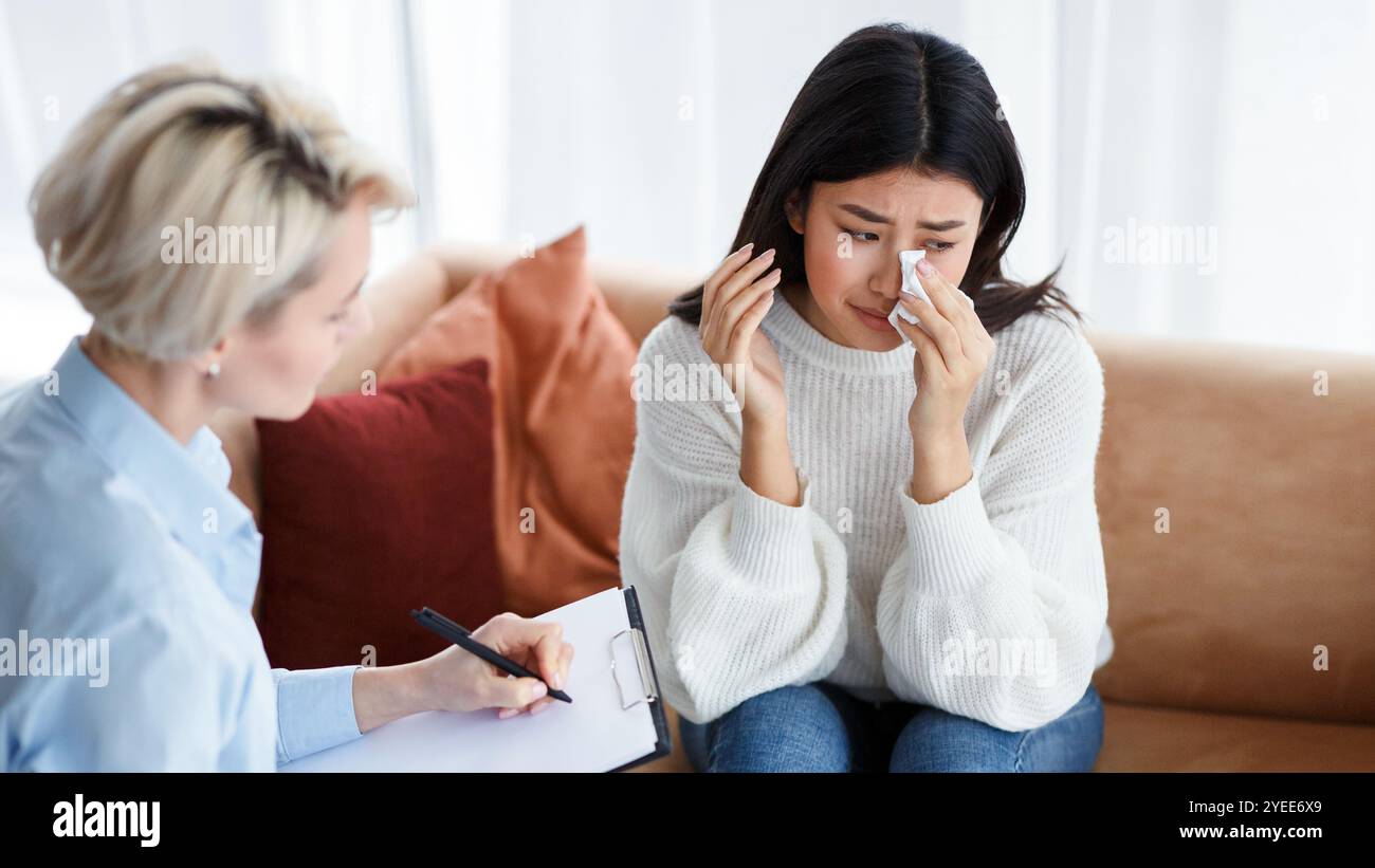 Asian Woman Crying Talking With Psychologist Sitting In Office Stock ...