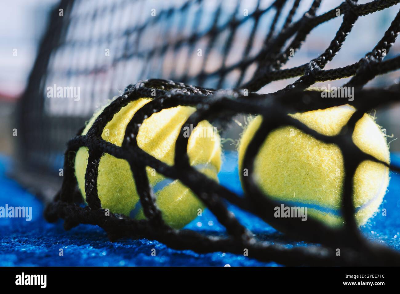 two balls behind the net on a paddle tennis court, concept of racket ...