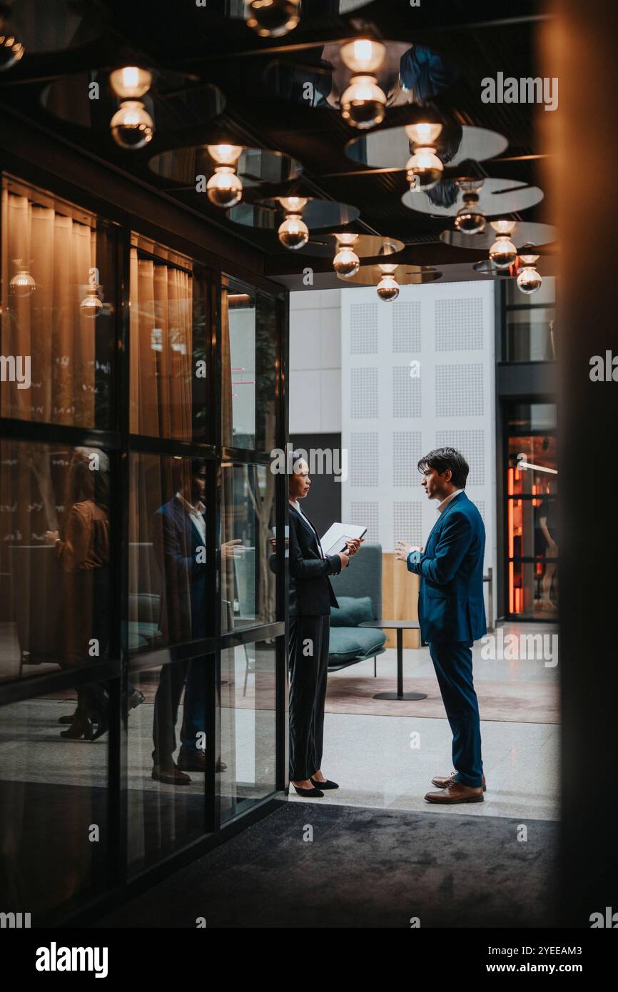 Side view of male and female entrepreneurs sharing strategies while ...