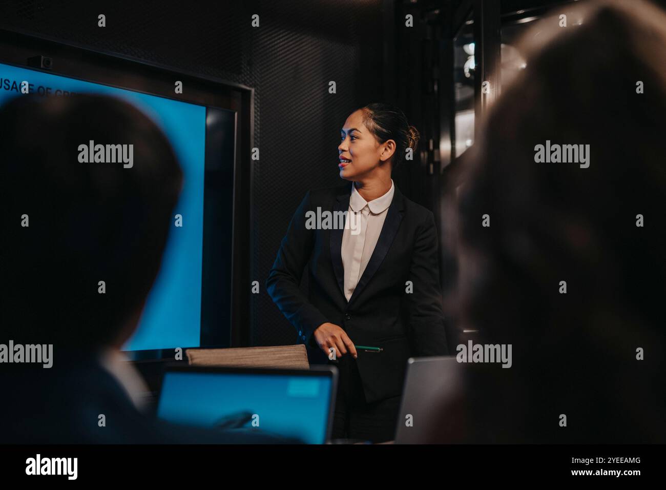 Female entrepreneur looking at projection screen while working in ...