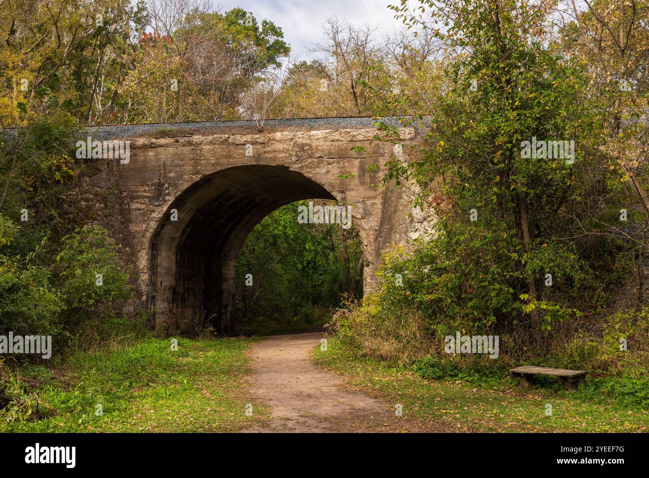 A hiking trail passing through a railroad arch bridge Stock Photo - Alamy