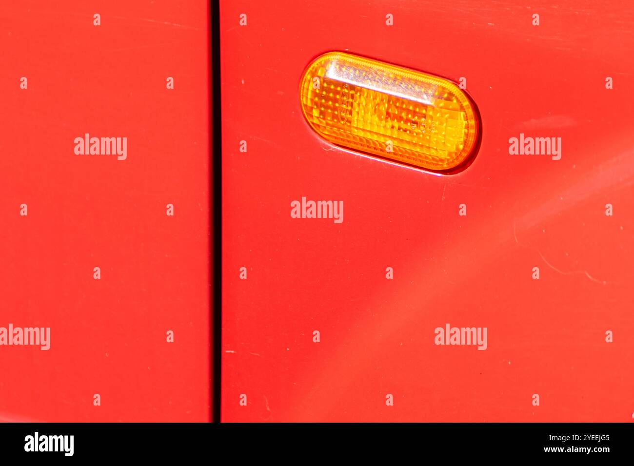 close-up view of the front side flasher of a red car. Driver side ...