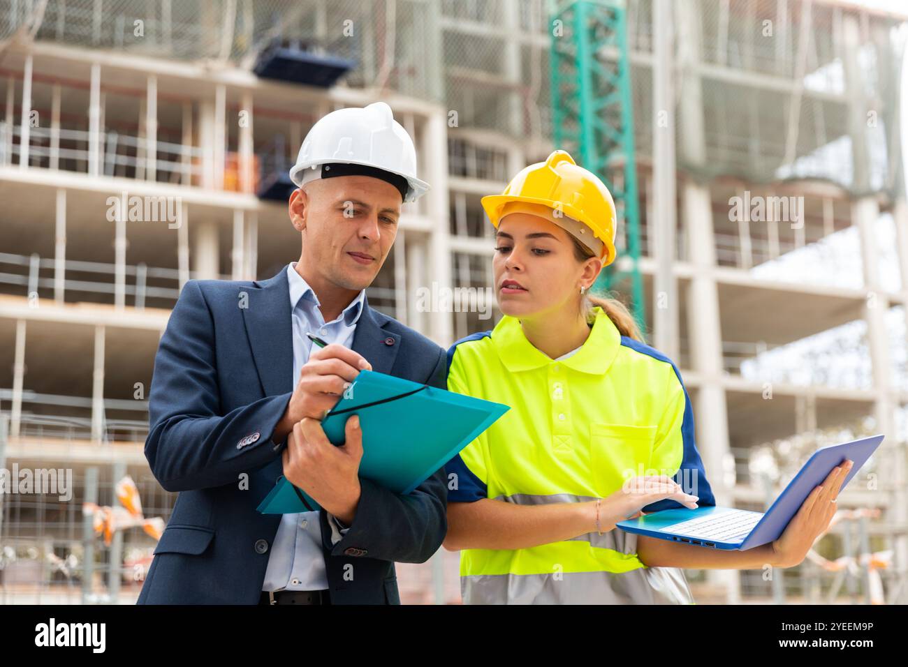 Two architects with laptop discussing construction plan Stock Photo - Alamy