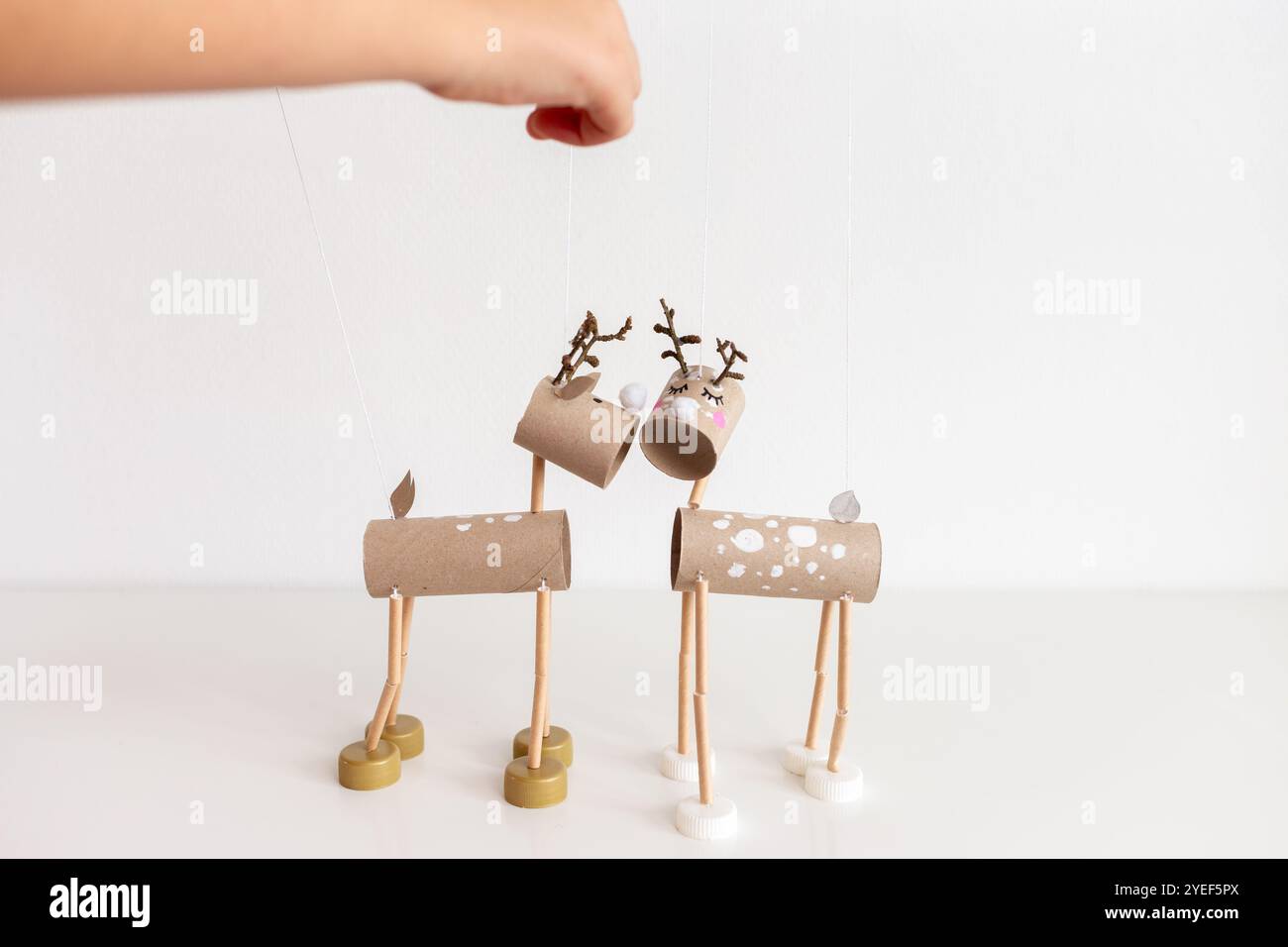Hand holding wooden stick controlling DIY reindeer puppets crafted from ...
