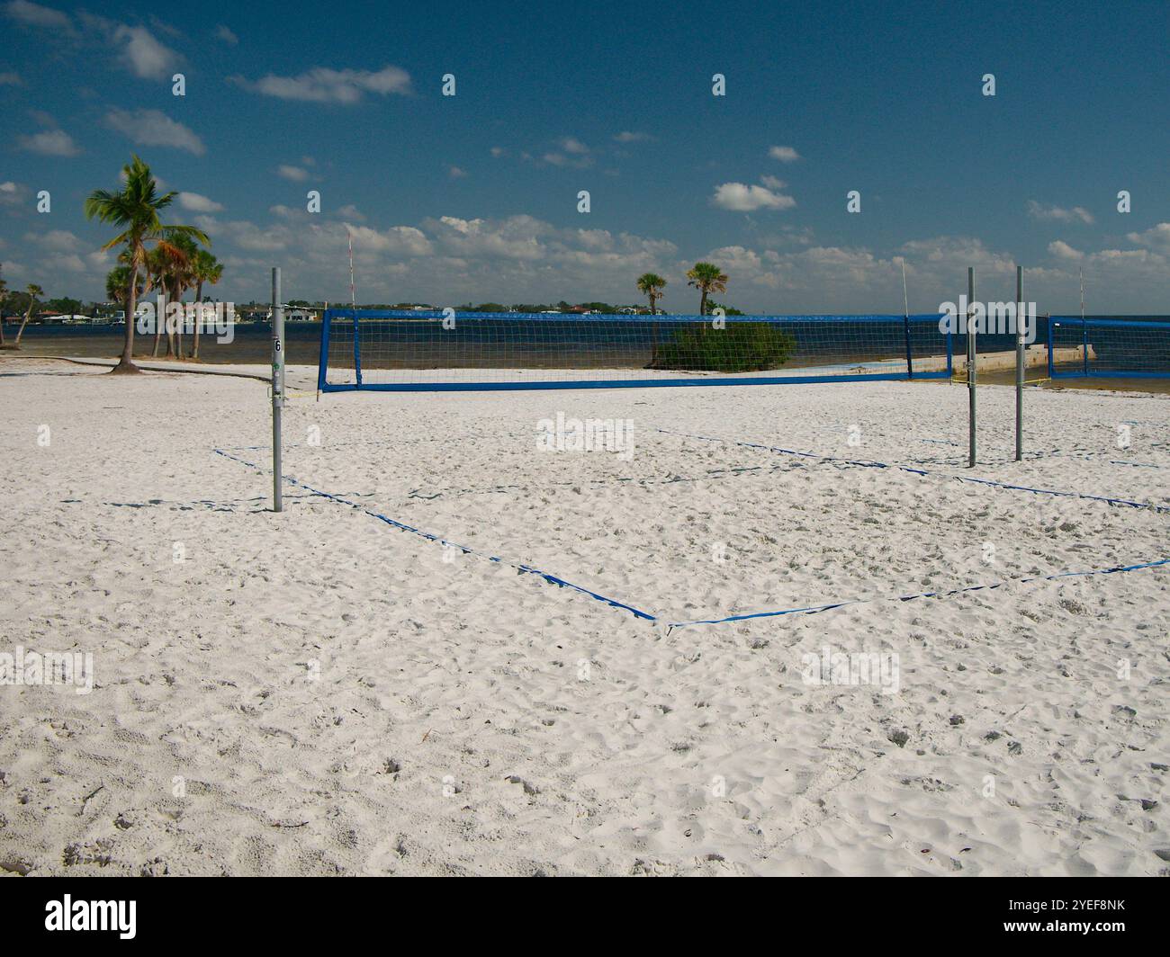 Wide view leading out to a beach volleyball net on white sandy beach ...
