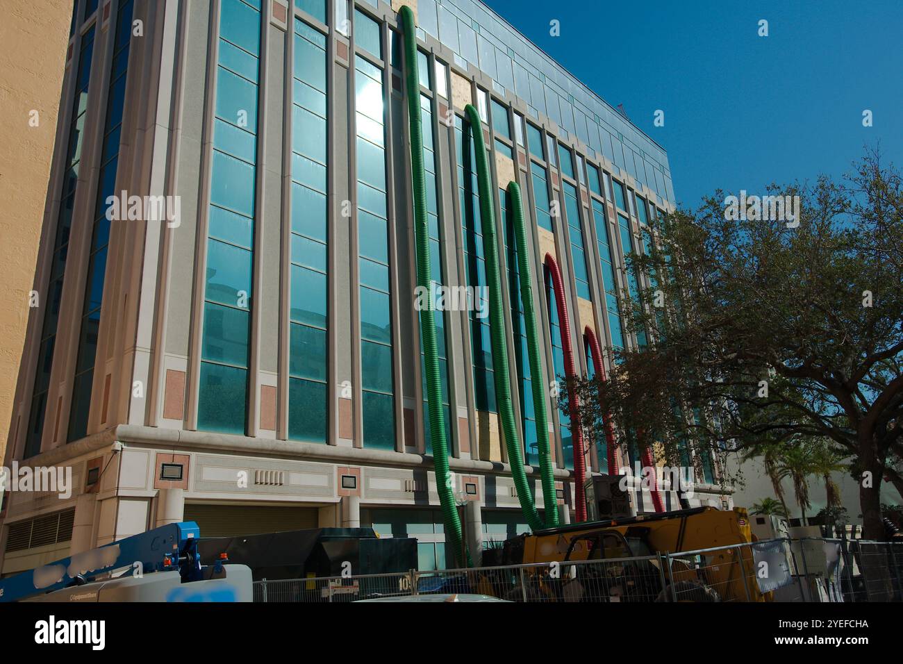 Tall modern Glass Building with temporary green and red AC duct tubes ...