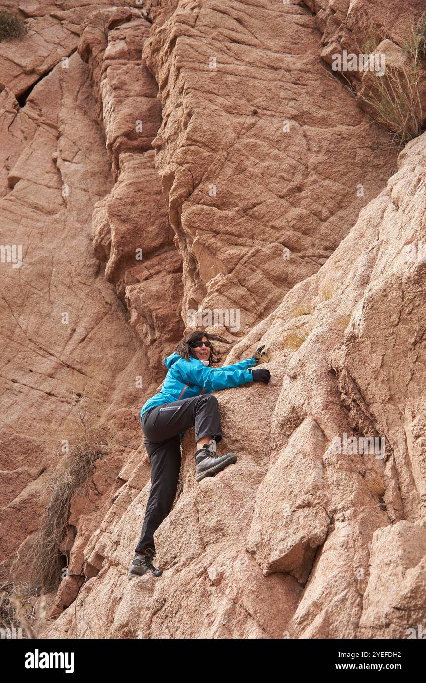 Strong woman climbing a rocky mountain wall in Mendoza, Argentina. Her ...