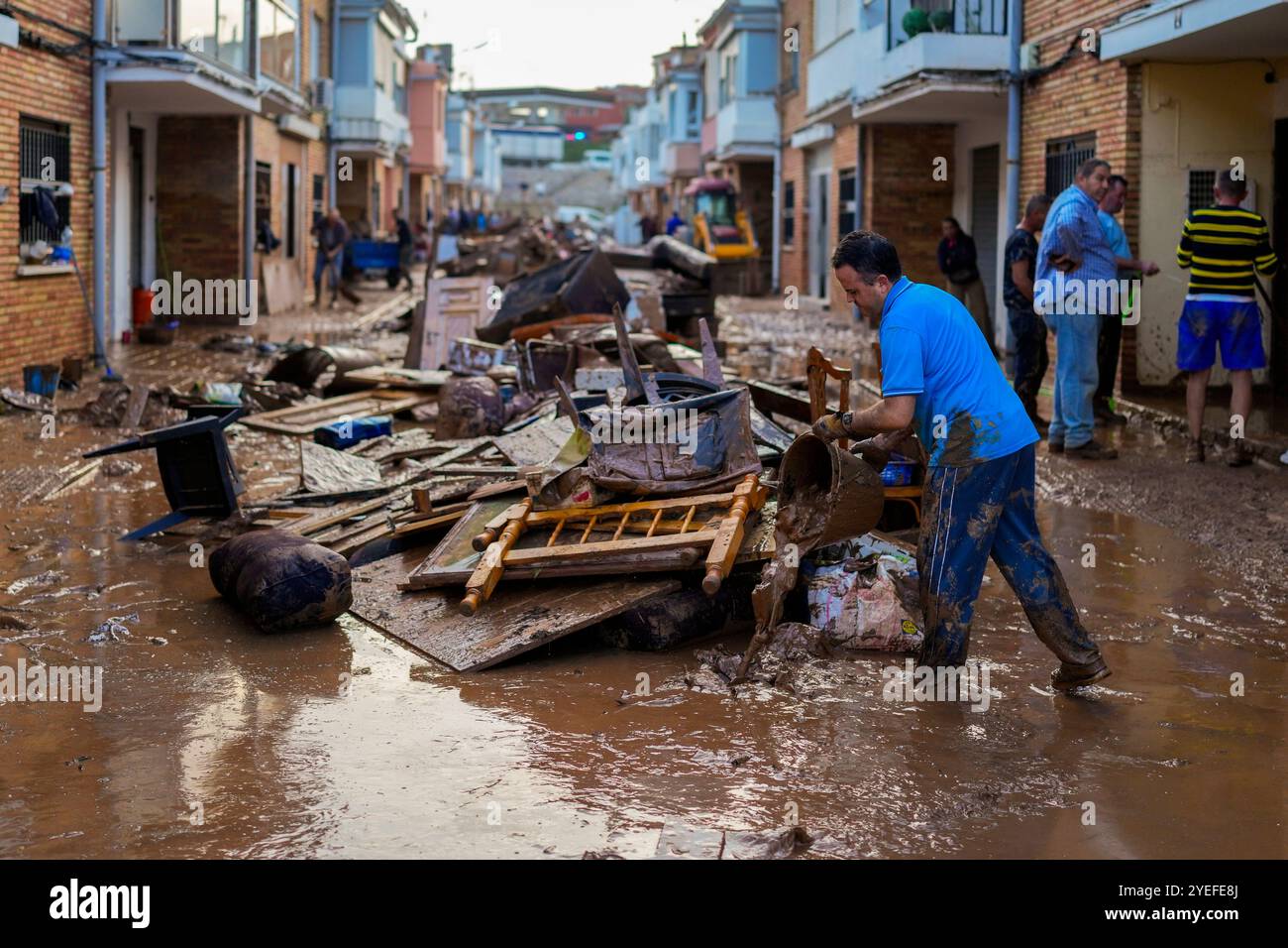 A man cleans his house affected by floods in Utiel, Spain, Wednesday ...