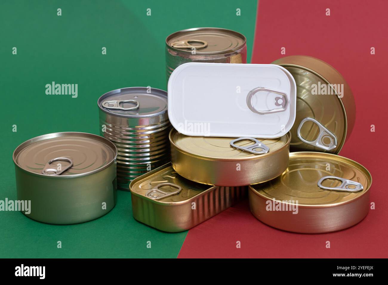 A Group of Stacked Tin Cans on Split Red and Green Background. Canned ...