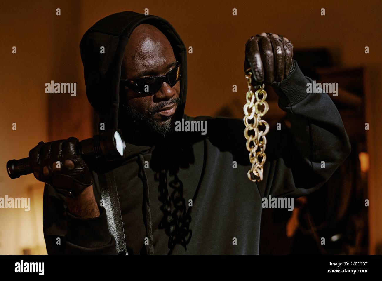 Medium close up of African American thief wearing hooded shirt and ...