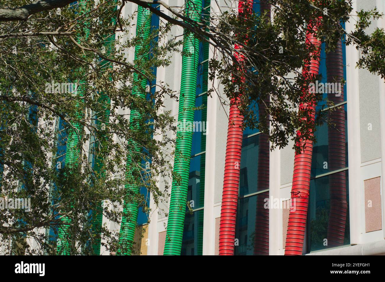 Tall modern Glass Building with temporary green and red AC duct tubes ...