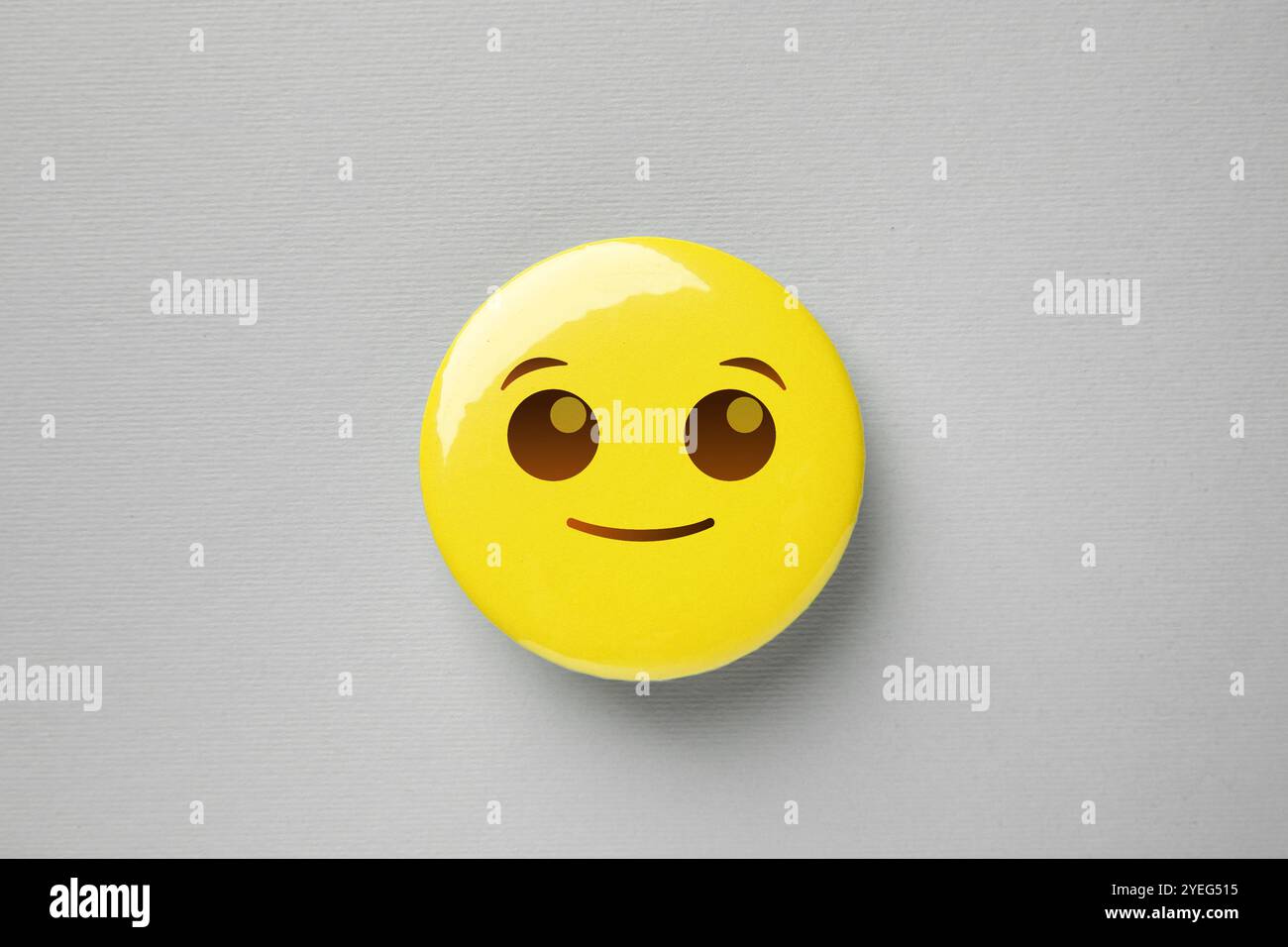 Badge with smiling face on grey background Stock Photo - Alamy