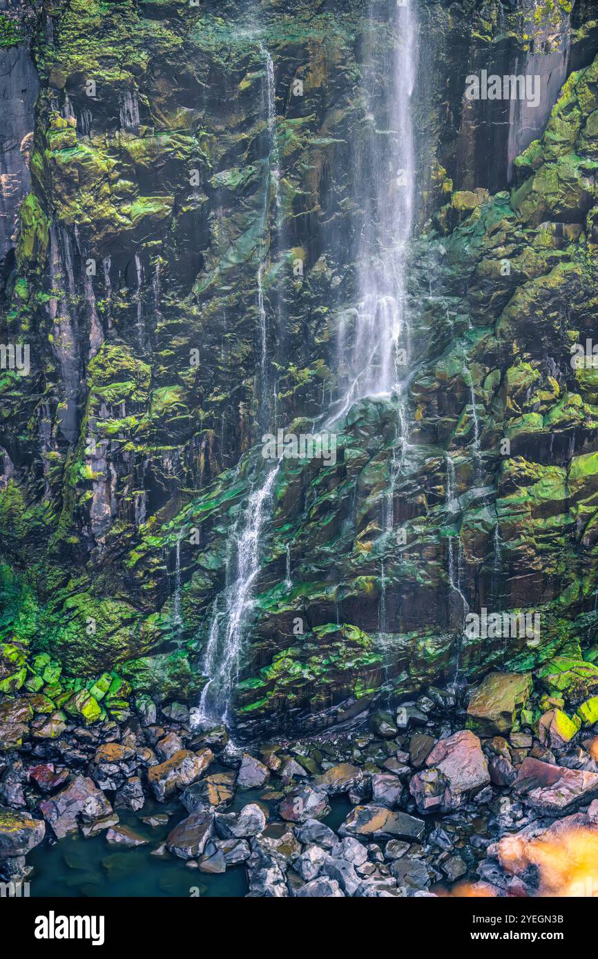 A stunning waterfall cascades down a rugged cliff, surrounded by lush ...