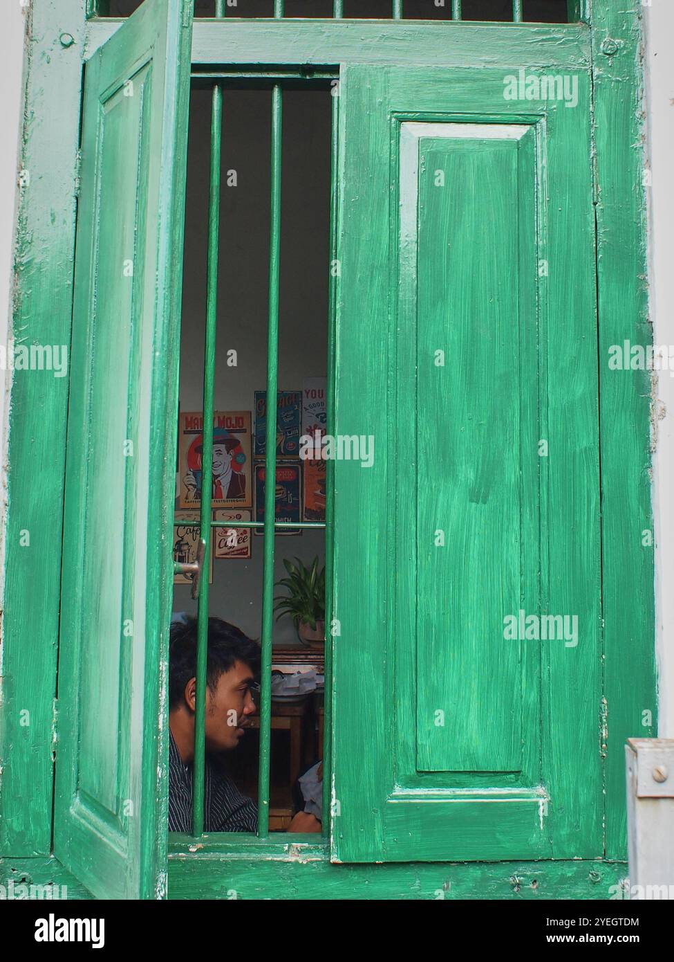 a man between two shutters of a coffee shop Stock Photo - Alamy