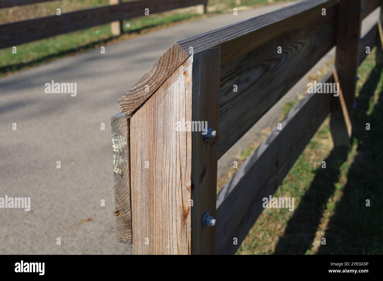 Wooden fence post with walking path in background Stock Photo - Alamy