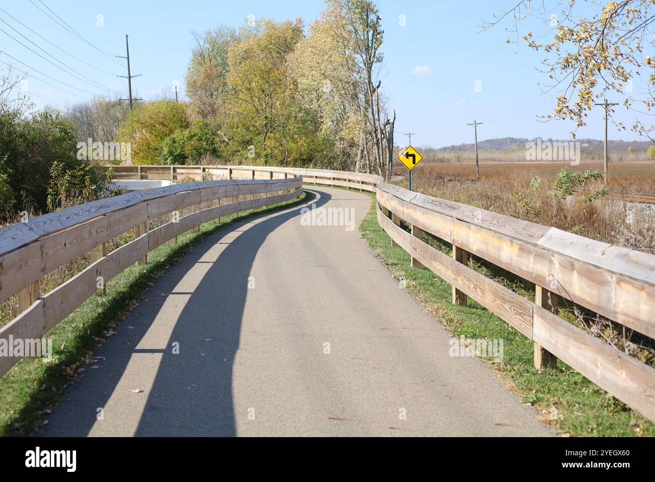 Asphalt bike and walking path with wooden guard rails Stock Photo - Alamy