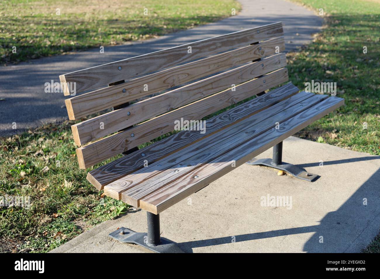 Solitary wooden park bench sitting alone in public park Stock Photo - Alamy