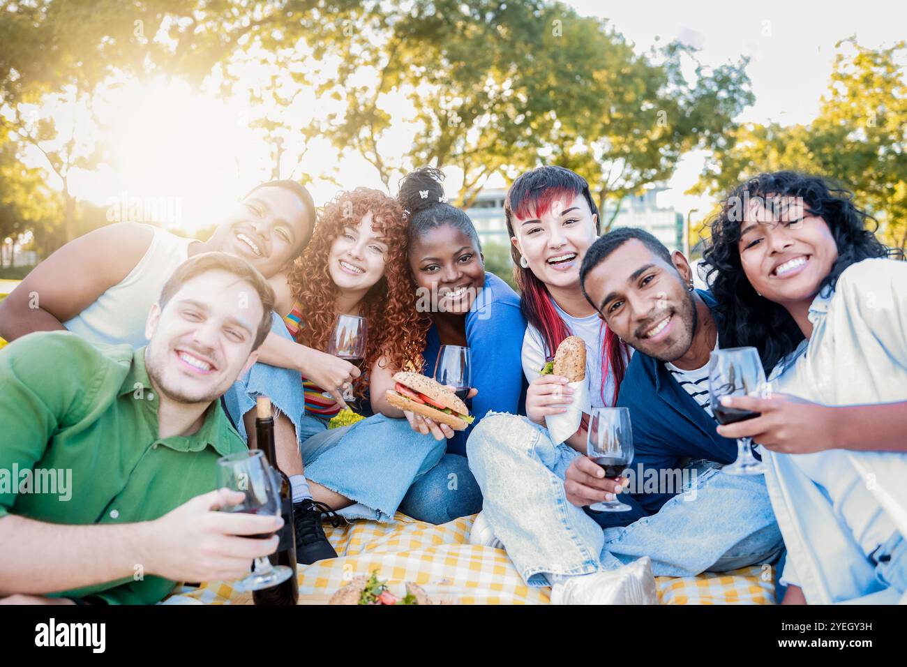 Group of diverse people having fun at garden party. Happy friends eat ...