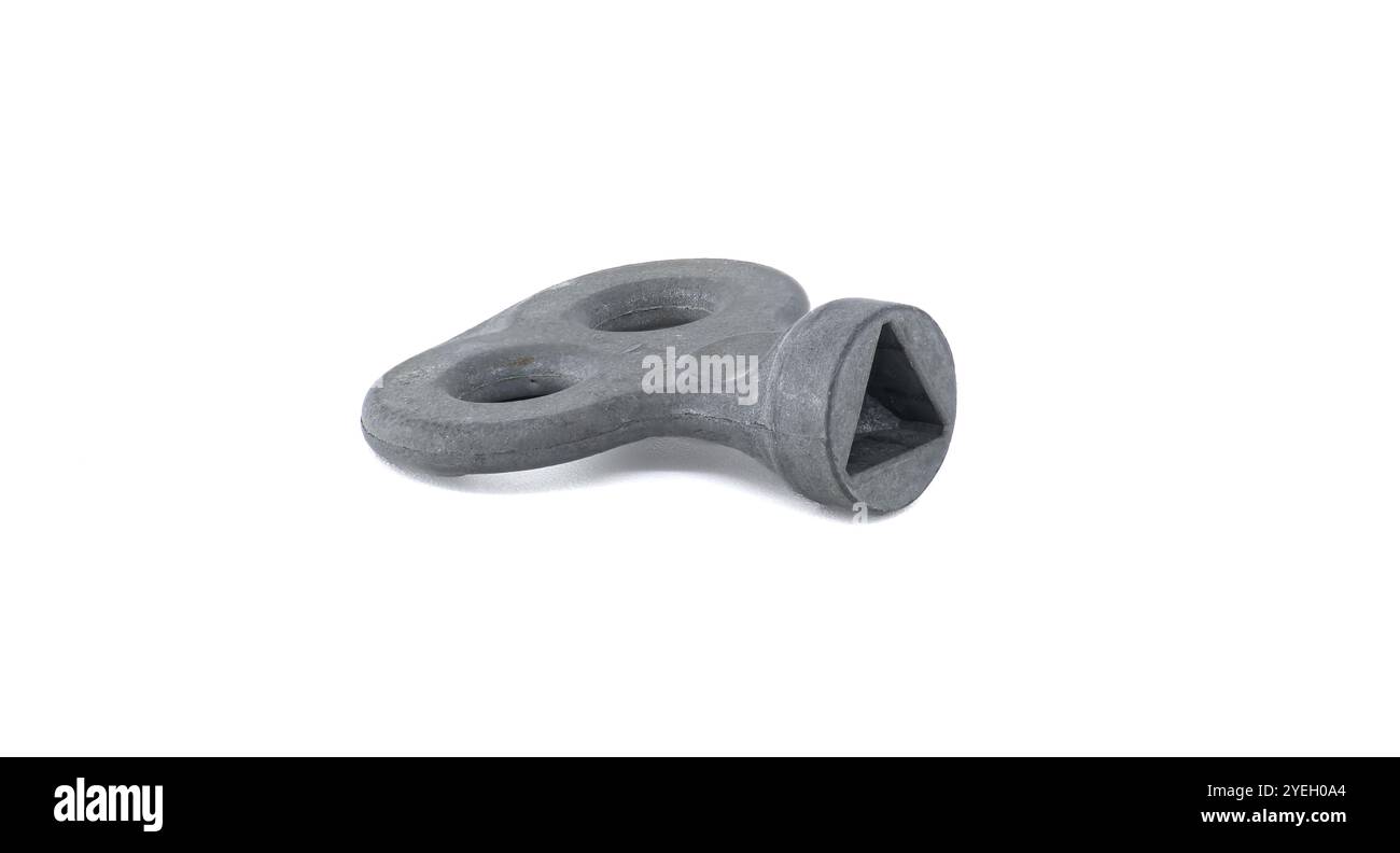 A vintage metal clock key with a two-hole design, isolated on a white ...