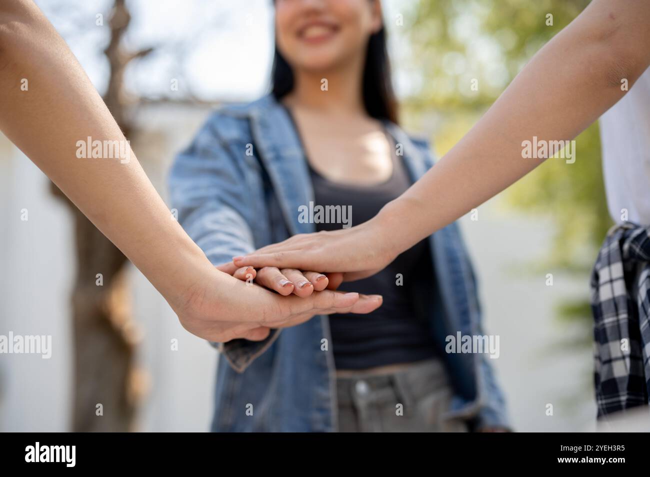 A close-up of college students putting their hands together while ...