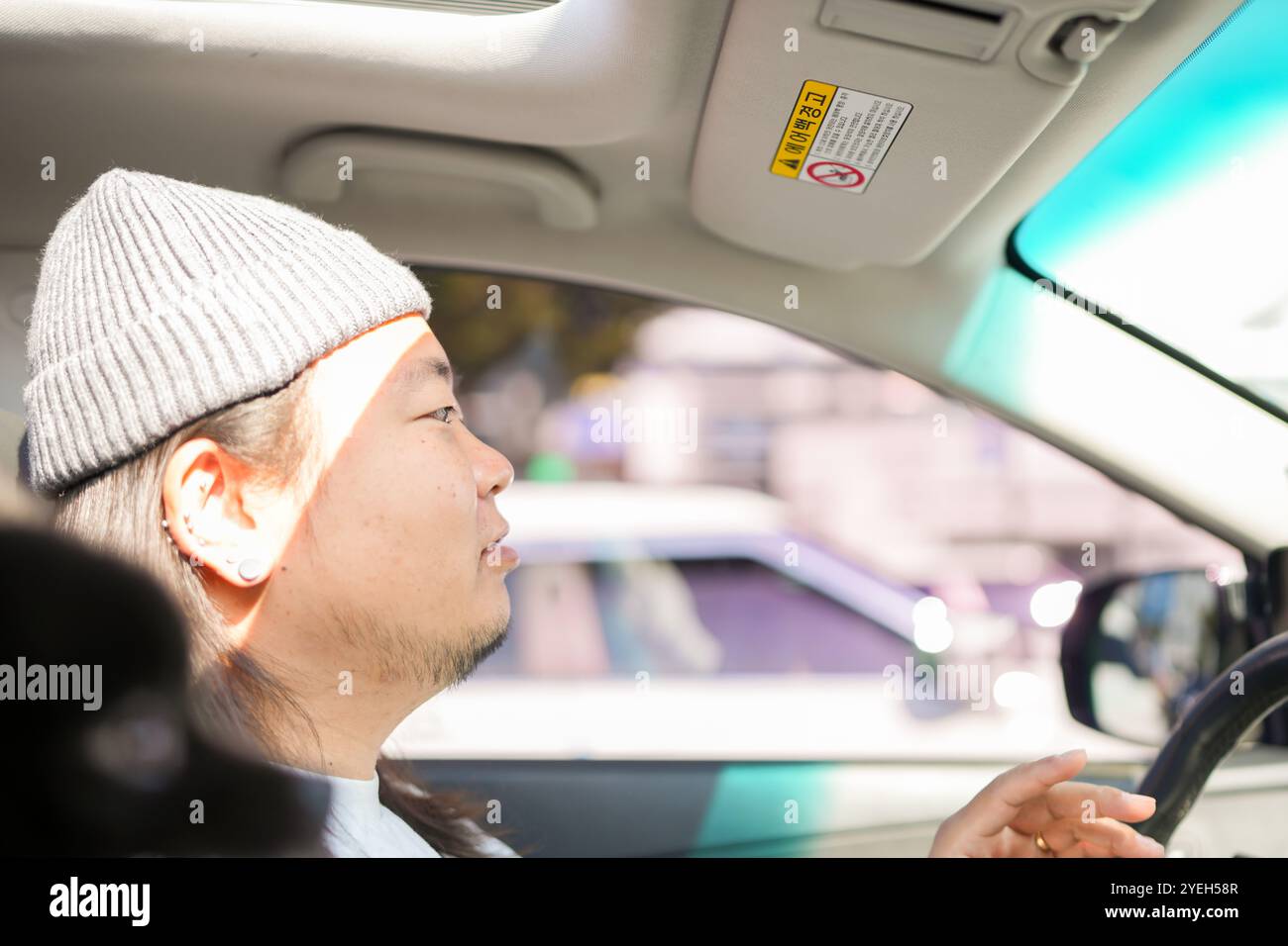 A Korean man in his 30s is driving a car in Pyeongnae-dong, Namyangju ...