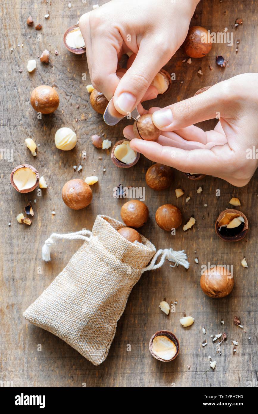 Top view of hands opening Macadamia nut with opener Stock Photo - Alamy