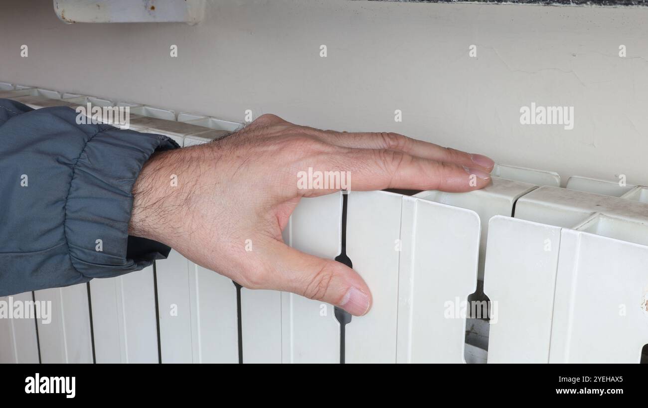 Hands of elderly man touching radiator to warm up Home environment with ...