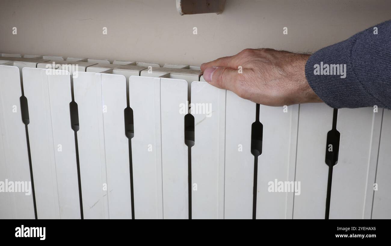 Hands of elderly man touching radiator to warm up Home environment with ...