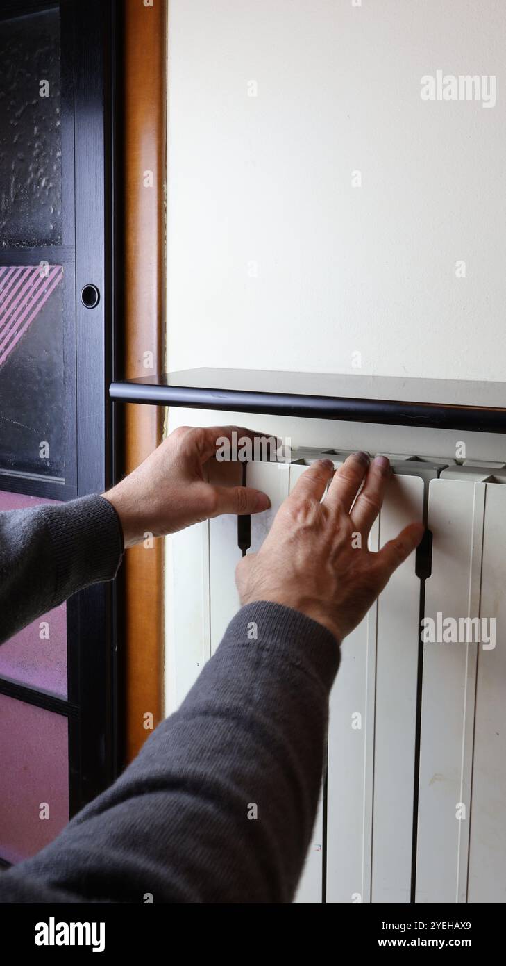 Hands of elderly man touching radiator to warm up Home environment with ...