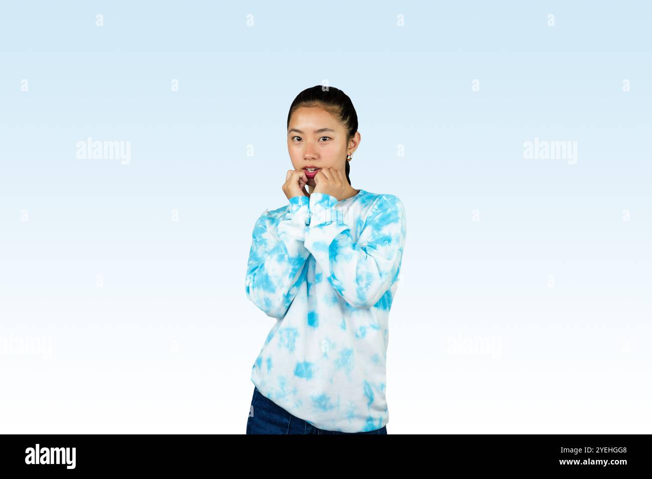 Yougn Asian girl with blue dress points and gives various expression ...