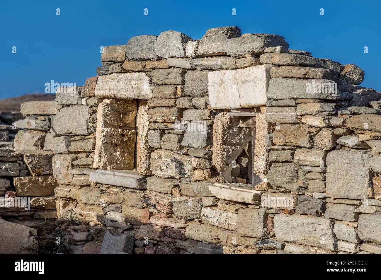 Ancient wall of a house on the archeological site. of Delos, Greece, a ...