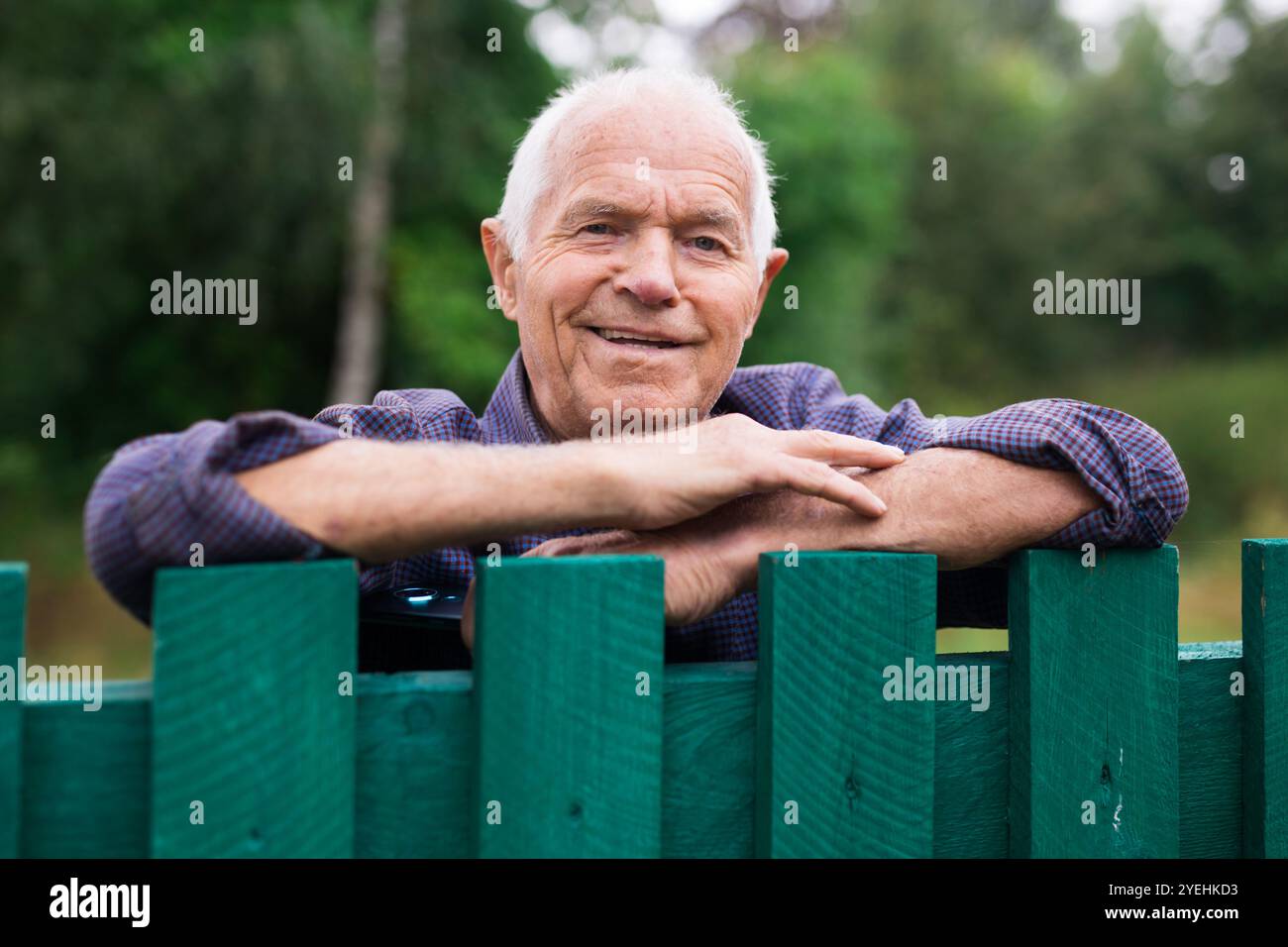 Old man standing beside fence Stock Photo - Alamy