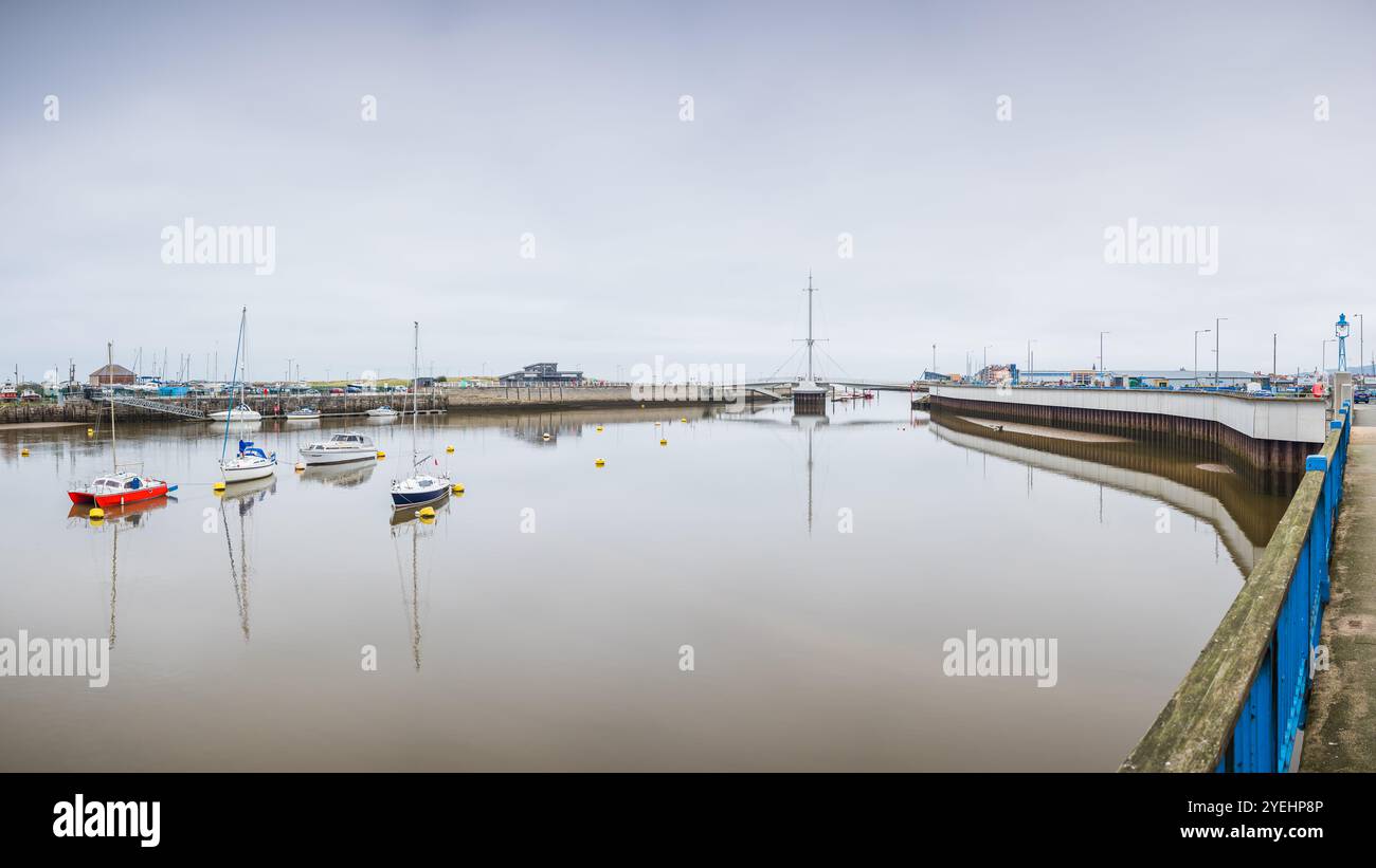 A multi image panorama of boats reflecting in the calm water of the ...