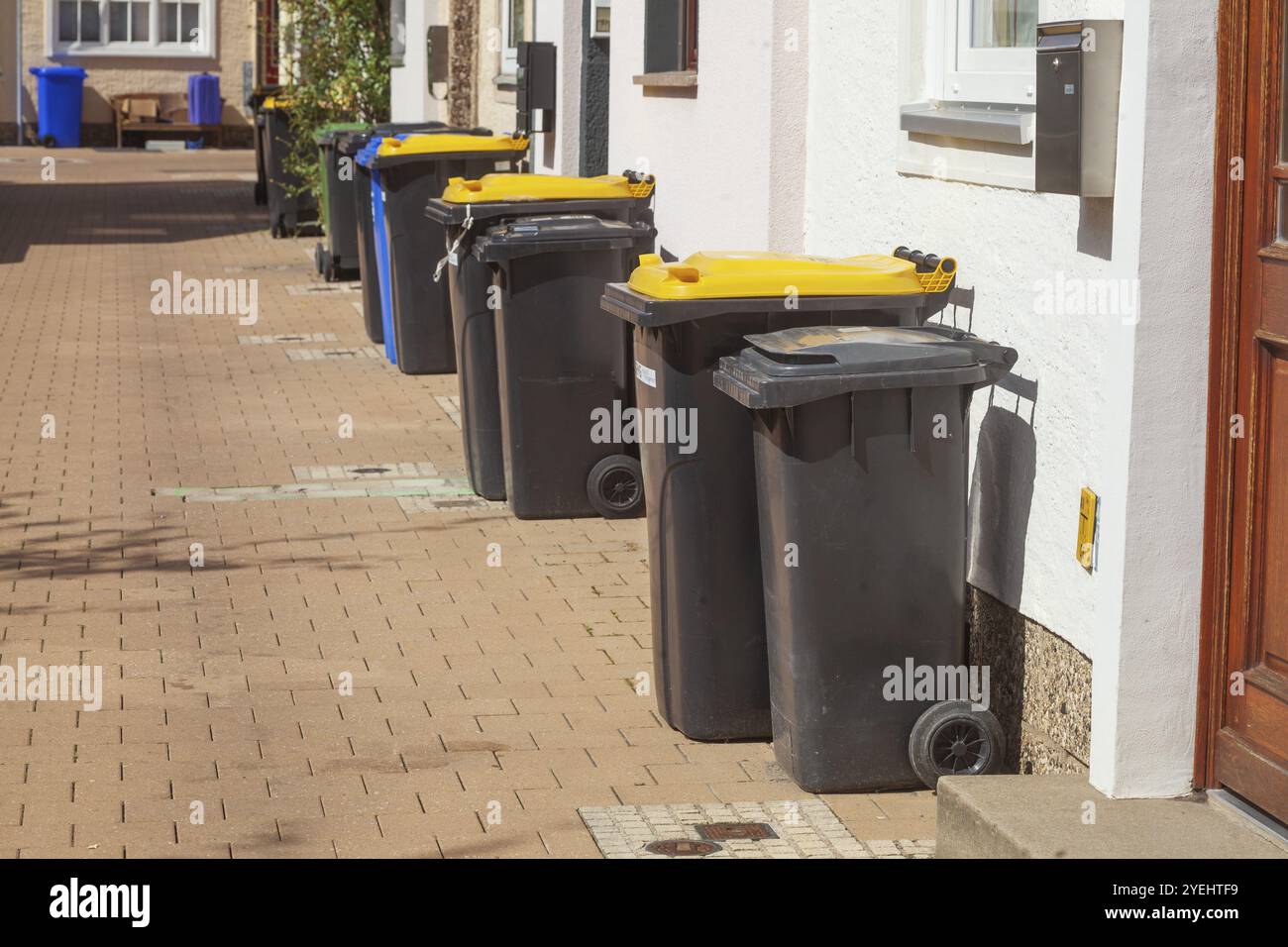 Various rubbish bins standing on the pavement in front of residential ...